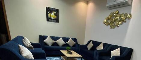 Suite, 2 quartos | Sala de estar | Televisor