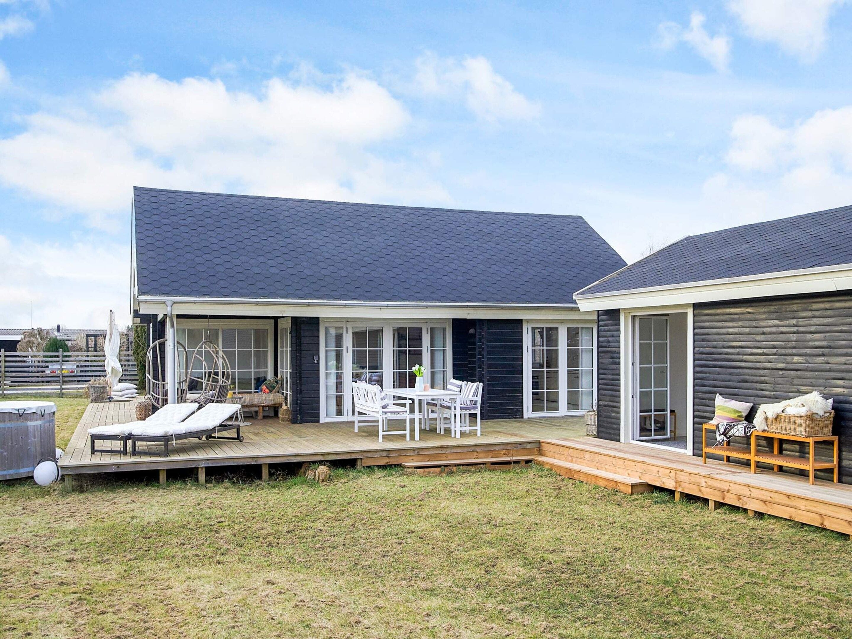 Uma casa moderna com um pátio, área de estar externa e espaço coberto.