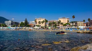 Uma área costeira com praia, edifícios e um barco.
