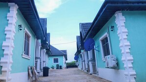 Rua estreita com casas que apresentam detalhes em branco e antenas parabólicas.