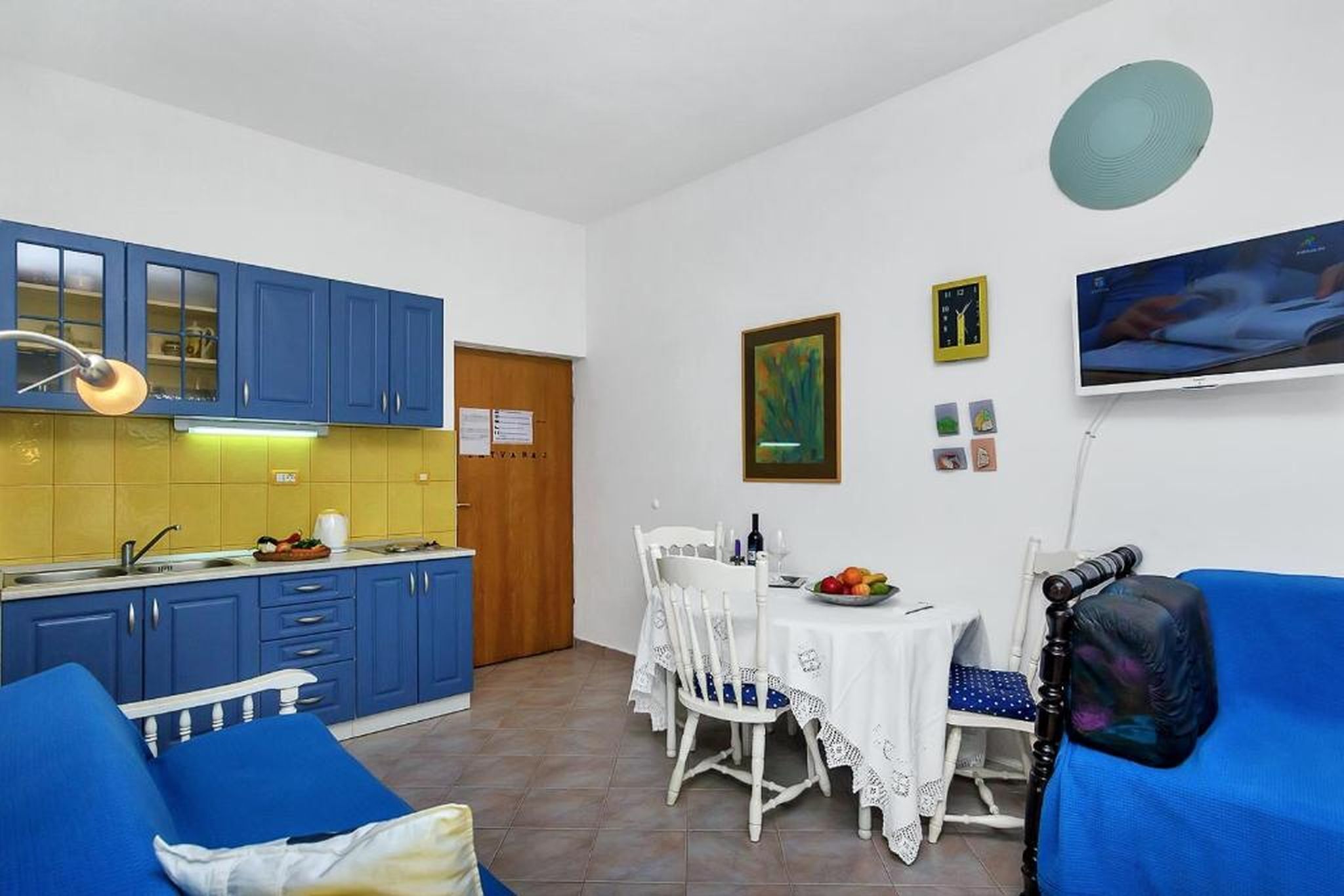 Um espaço compacto com cozinha compacta, área de refeições e televisão.