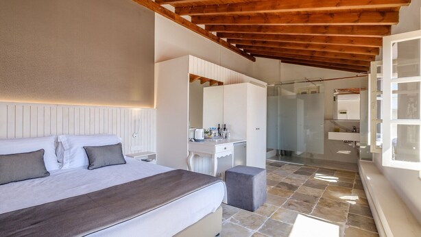 Quarto com cama, mesa de cabeceira e armário.