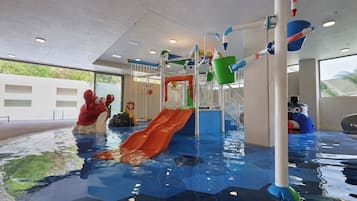Área de recreação aquática interna com escorregadores e fontes.