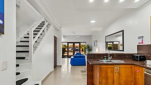 Uma cozinha moderna com bancada de madeira, uma pia e um espelho acima.