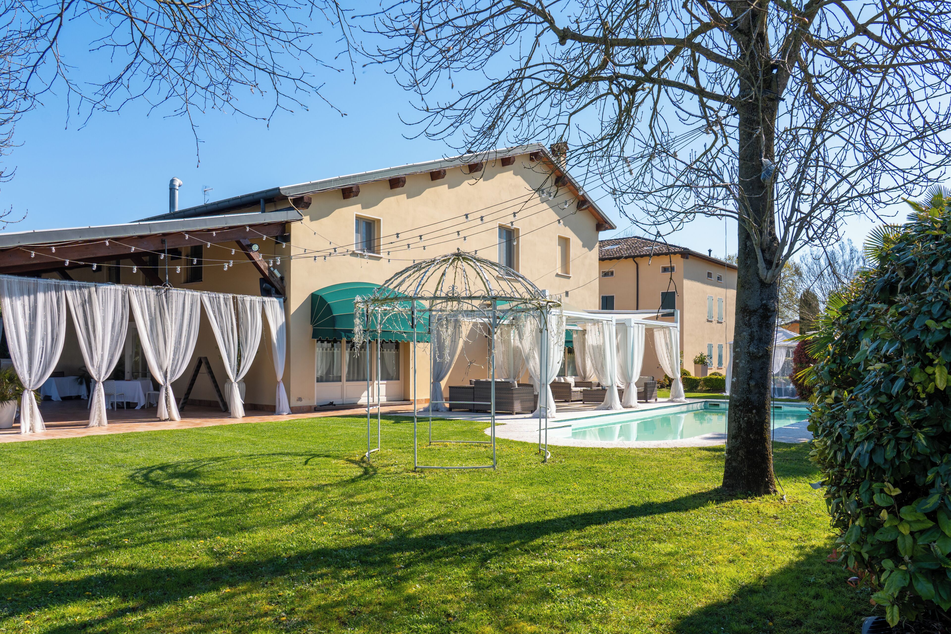 Uma casa com piscina, área de estar coberta ao ar livre e gramado.