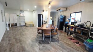 Cozinha moderna com mesa de jantar, cadeiras e frigorífico.