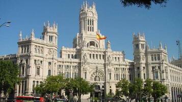 Um edifício grande e ornamentado com arquitetura clássica, apresentando diversas torres e estátuas.