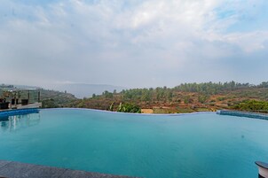 Uma grande piscina ao ar livre com vista para uma paisagem montanhosa.