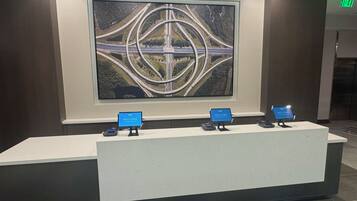 Uma receção com um grande mapa rodoviário emoldurado acima e dois ecrãs digitais de boas-vindas.