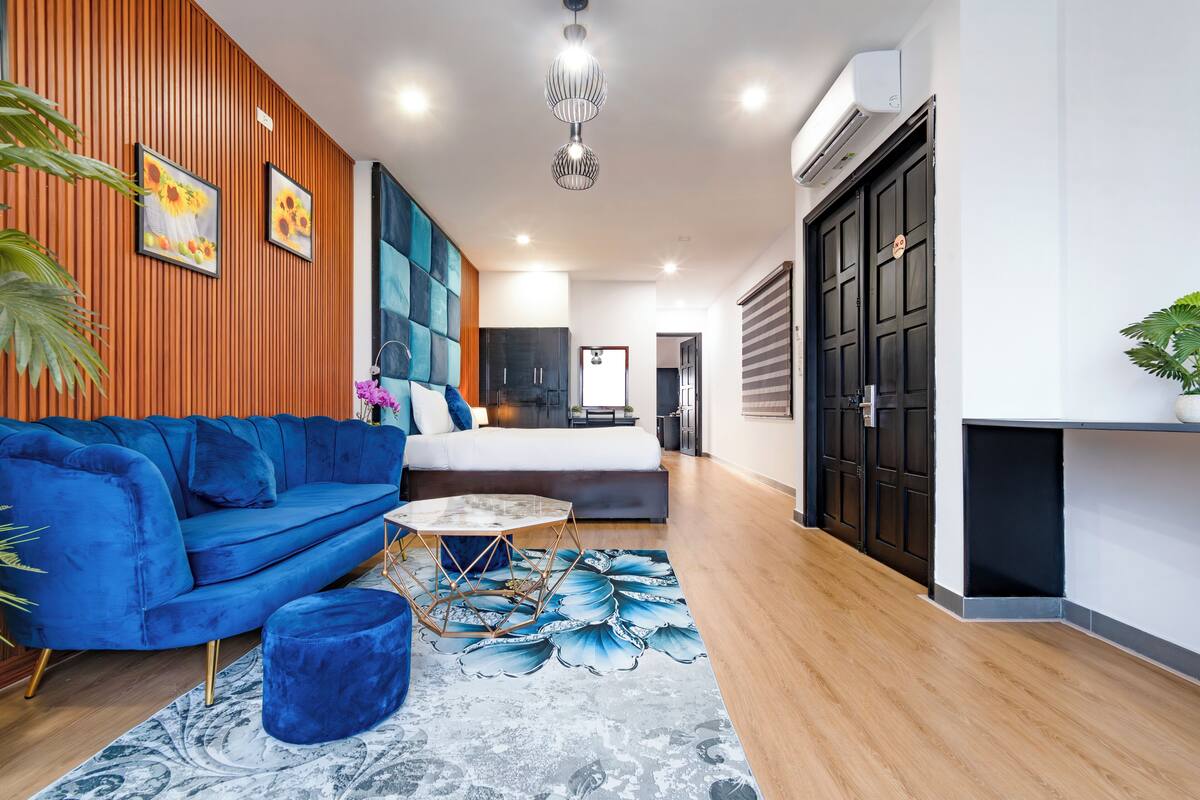 Uma sala de estar moderna com um sofá azul, uma mesa de centro e um tapete estampado.