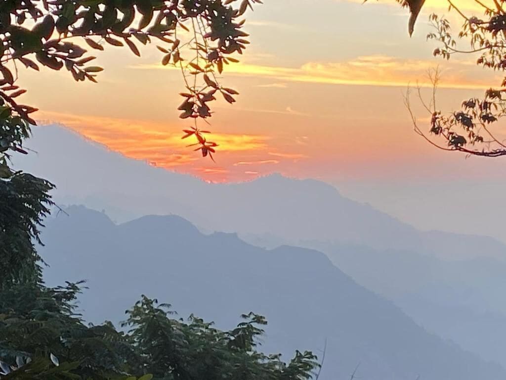 Paisagem montanhosa com um pôr do sol.