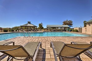 Uma área de piscina com espreguiçadeiras e um gazebo.