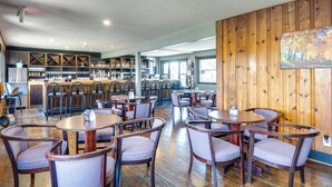 Um restaurante com painéis de madeira, área de bar e diversos arranjos de assento.