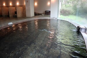 Área de spa com hidromassagem, assentos e vista para o exterior.