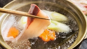 Uma panela quente com vários ingredientes a serem cozinhados.