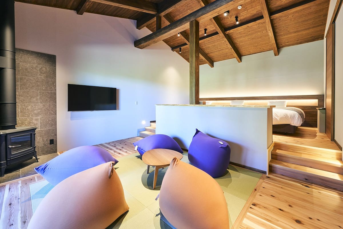 Um interior moderno com lareira, cama e televisão.