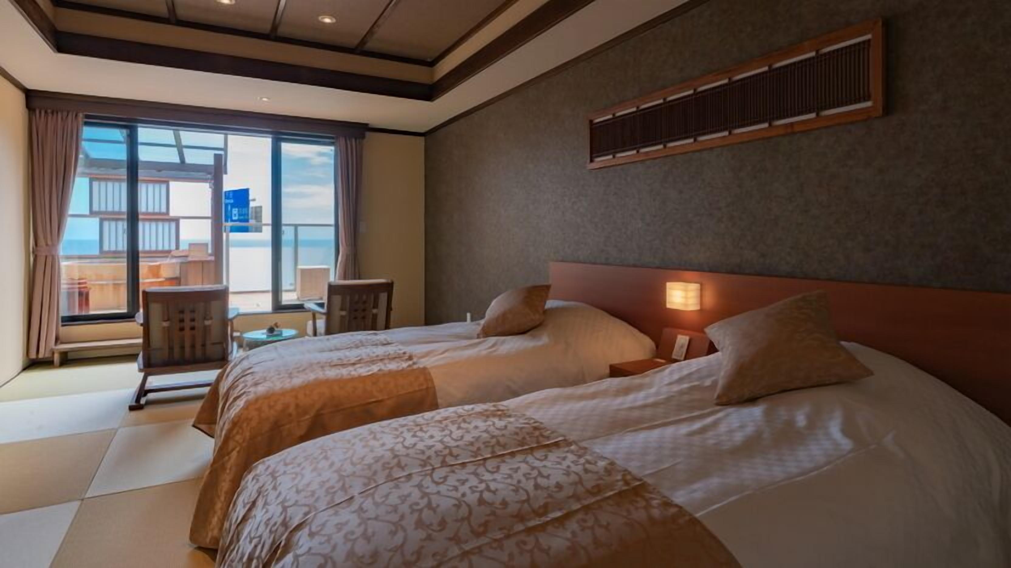 Quarto de hotel com uma cama grande, uma escrivaninha e vista para o mar.