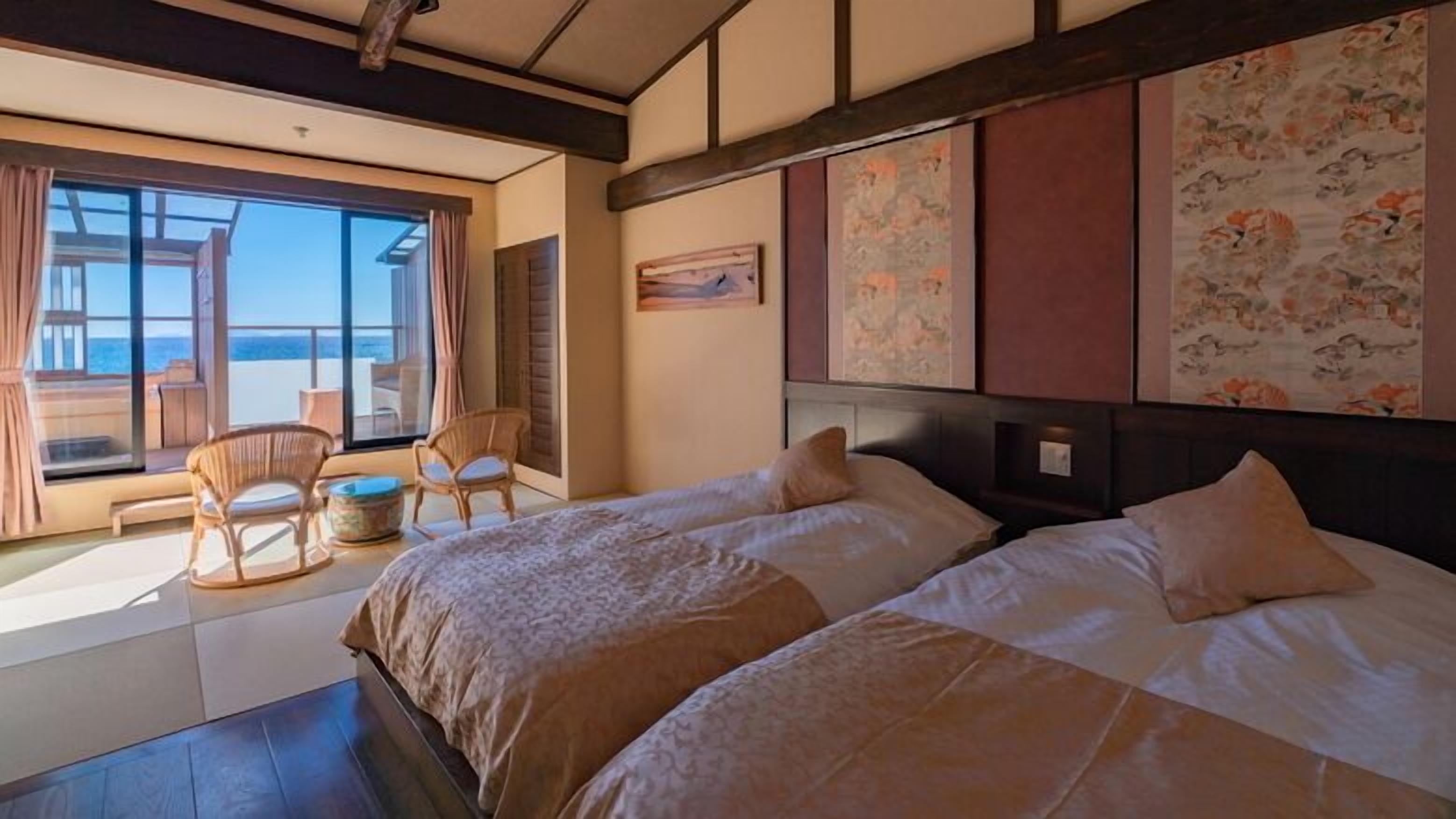 Quarto de hotel com duas camas, uma janela ampla com vista e decoração japonesa tradicional.