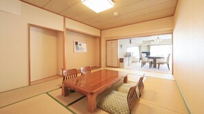 Quarto japonês tradicional com piso de tatame, mesa de madeira e tela deslizante shoji.