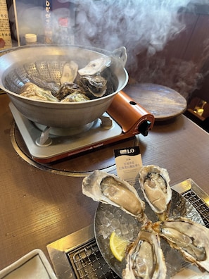 Cozinha com uma panela no fogão, uma tigela com ostras e um aviso indicando que as ostras estão à venda.