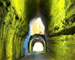 Um túnel com arco de concreto e um caminho reto que o atravessa.