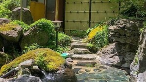 Um edifício tradicional japonês com um caminho de pedra que leva a um espelho d'água límpido.