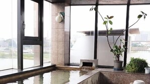 Área interna de piscina moderna com vista desobstruída para o horizonte da cidade através de grandes janelas.