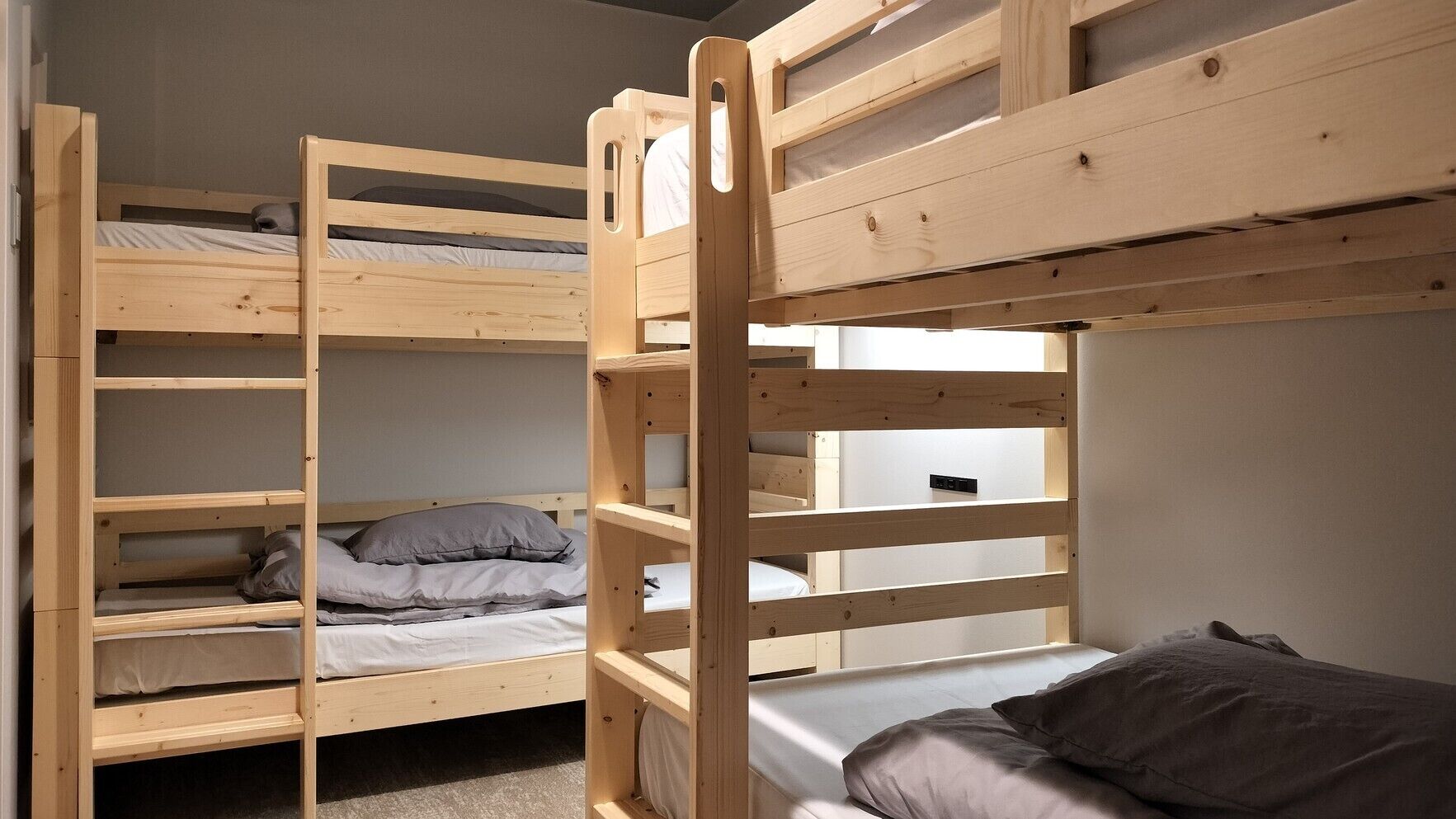 Quarto com beliche, escrivaninha e janela.
