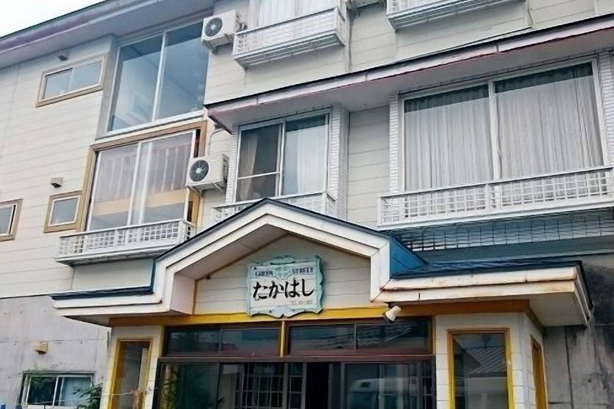 Um edifício com várias janelas, uma placa e uma entrada com portão.