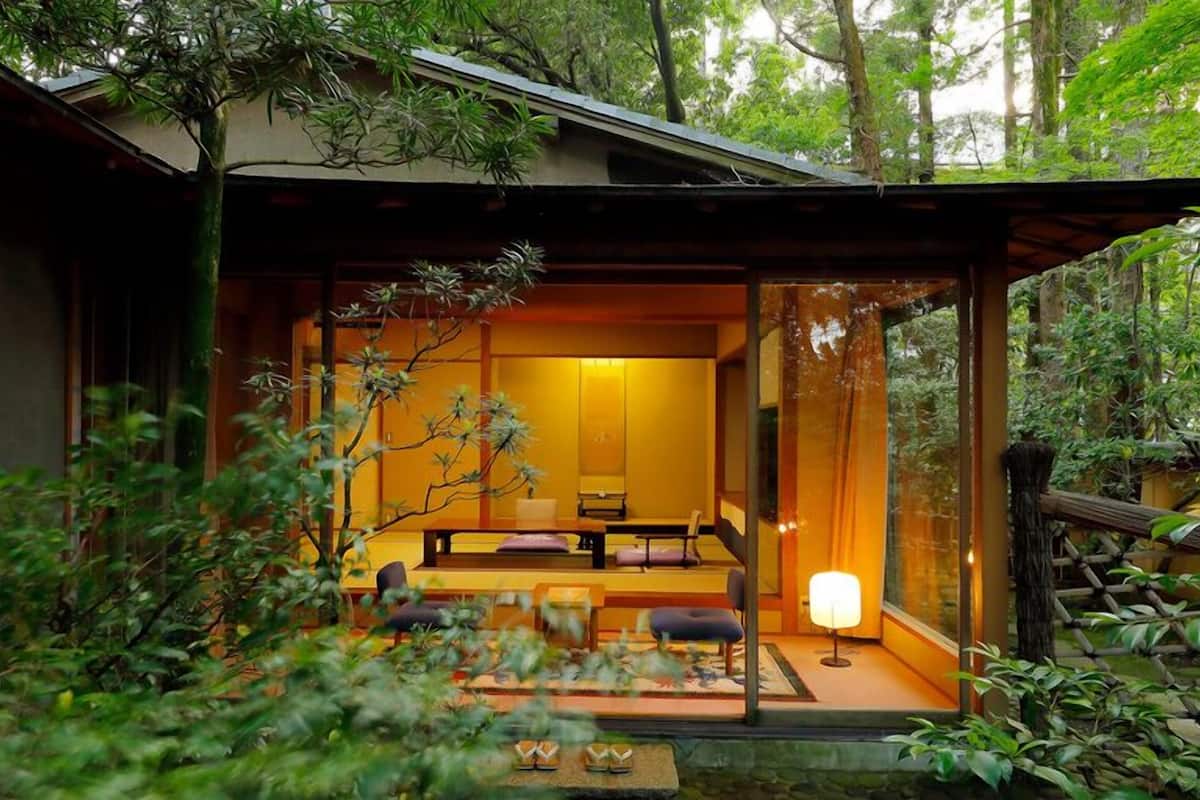 Um quarto em estilo japonês tradicional, com tatames, uma mesa baixa e um portas correderas.