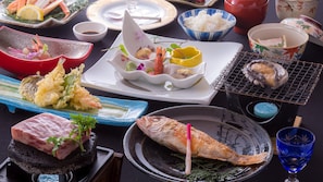 Diversos pratos japoneses sobre uma mesa, incluindo sushi, sashimi e tempura.