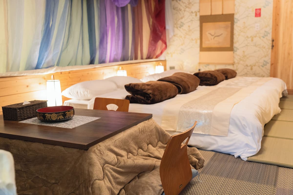 Quarto de hotel com cama, mesa de cabeceira e uma cadeira.