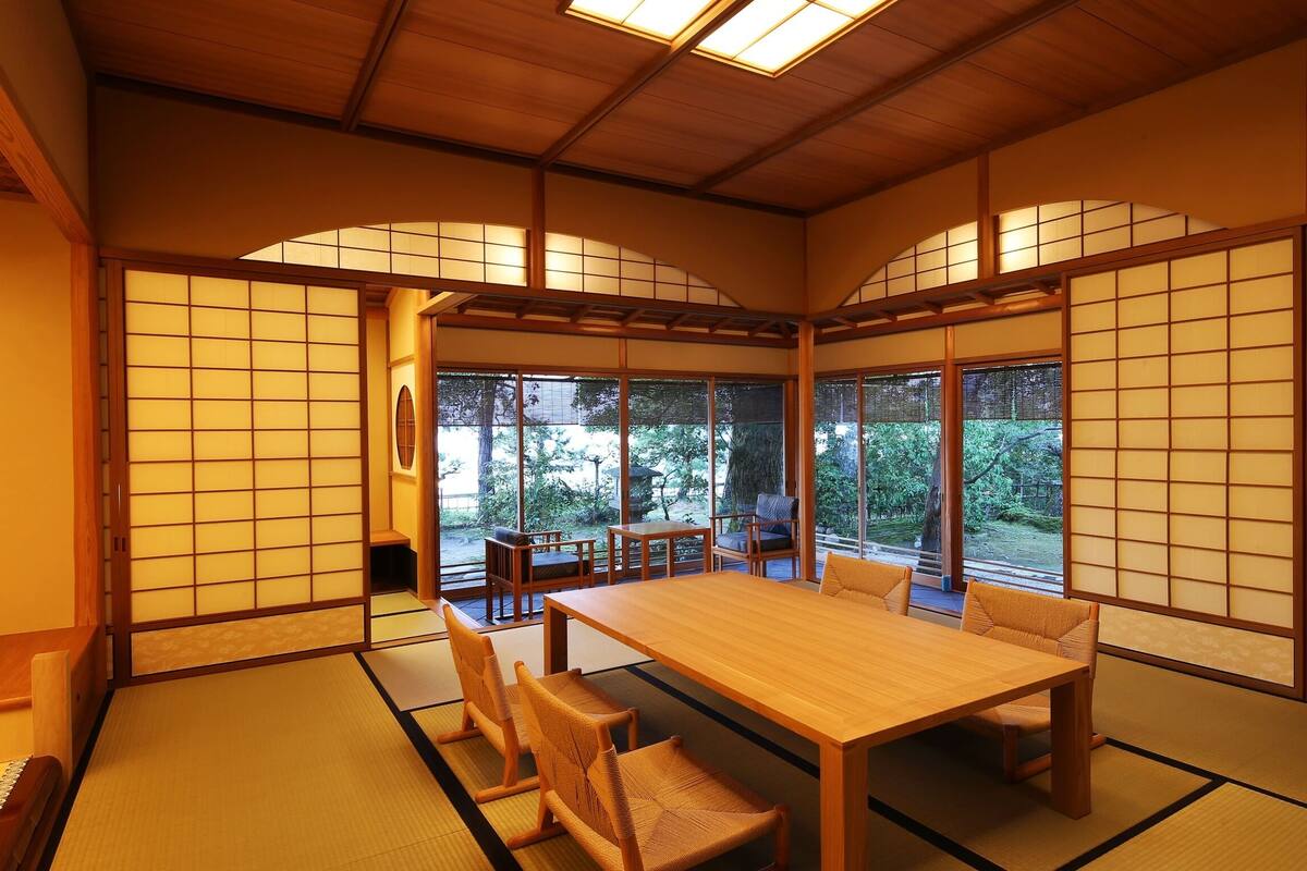 Um quarto japonês tradicional, com tatames, uma mesa baixa e portas deslizantes.