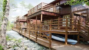 Uma cabana de madeira com um deck e um barco atracado na frente.