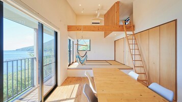 Quarto espaçoso com ampla janela para uma vista panorâmica, teto de madeira e rede.