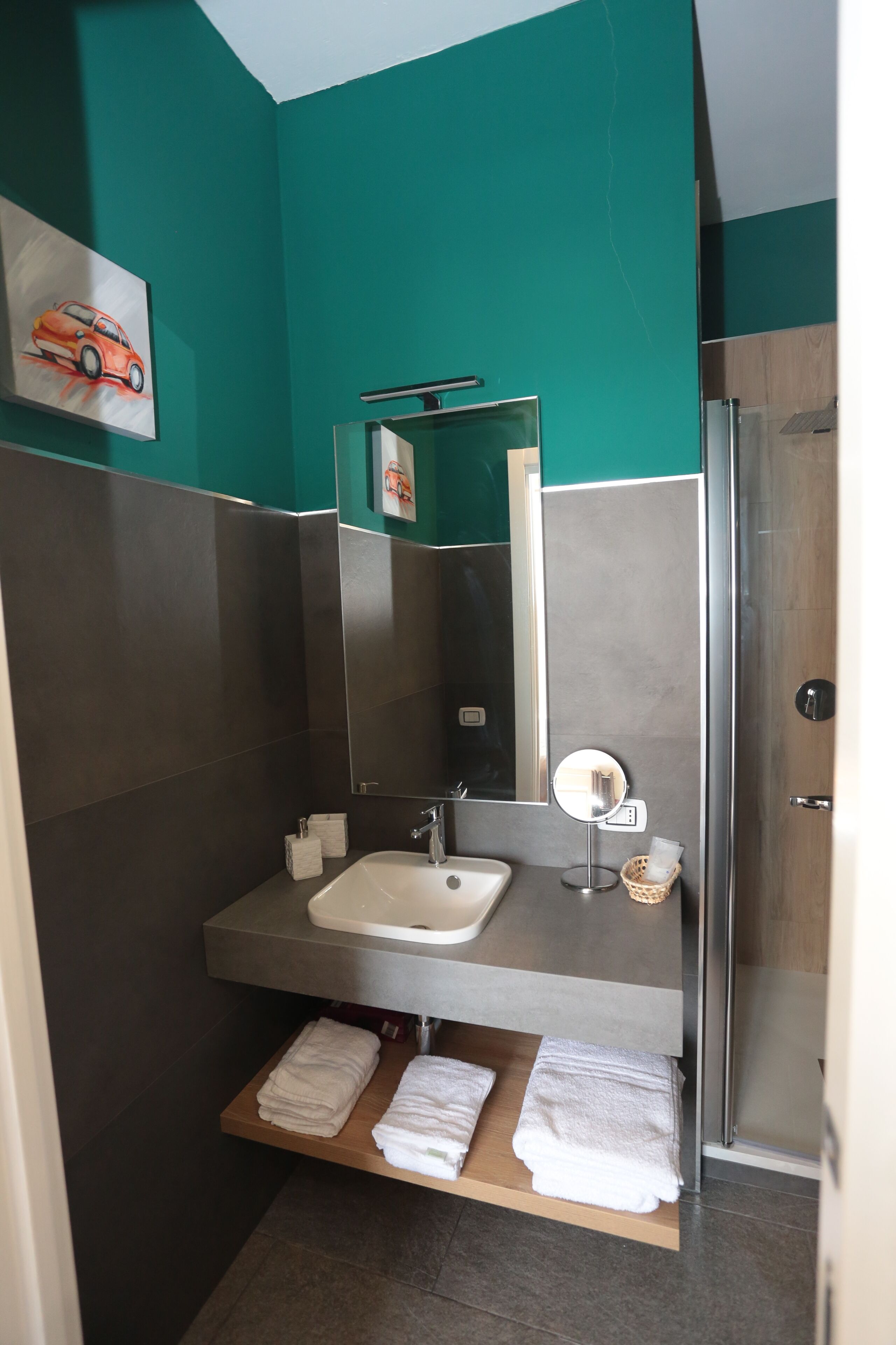 Uma casa de banho moderna com um espelho grande, uma pia e um porta-toalhas.