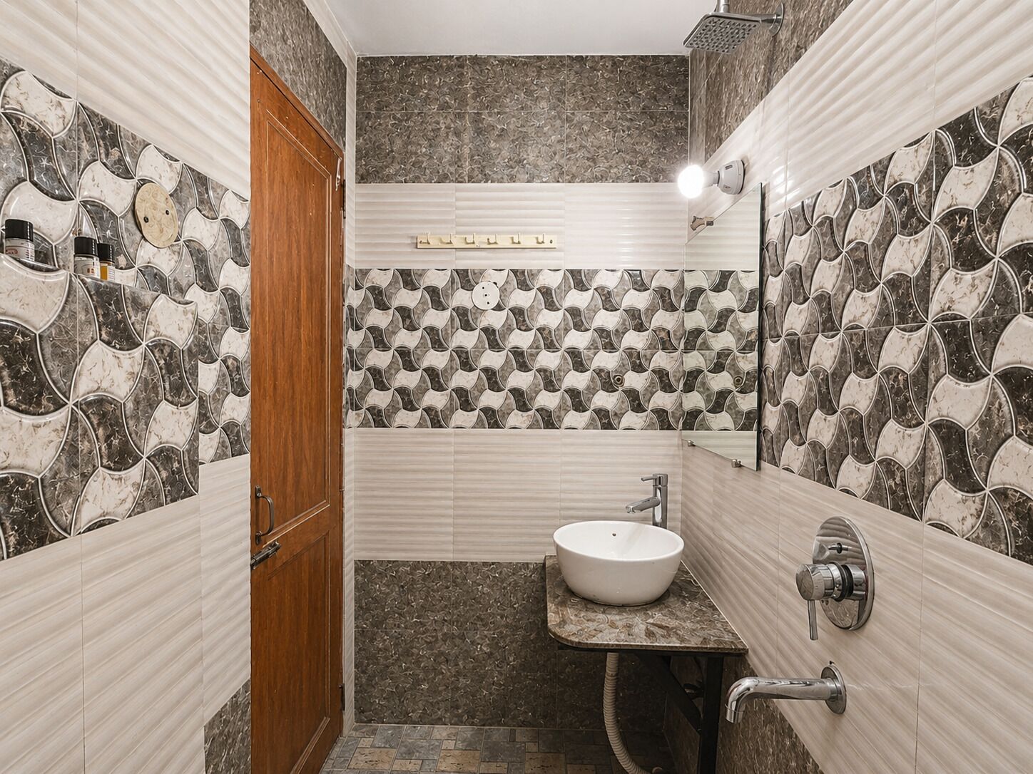 Uma casa de banho com lavatório, espelho e chuveiro.