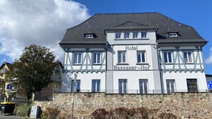 Um hotel de dois andares com fachada de pedra e uma placa com a inscrição 'Hotel Nassauer-Hof'.