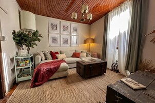 Uma sala de estar aconchegante com um sofá, uma mesa de centro e uma estante de livros.