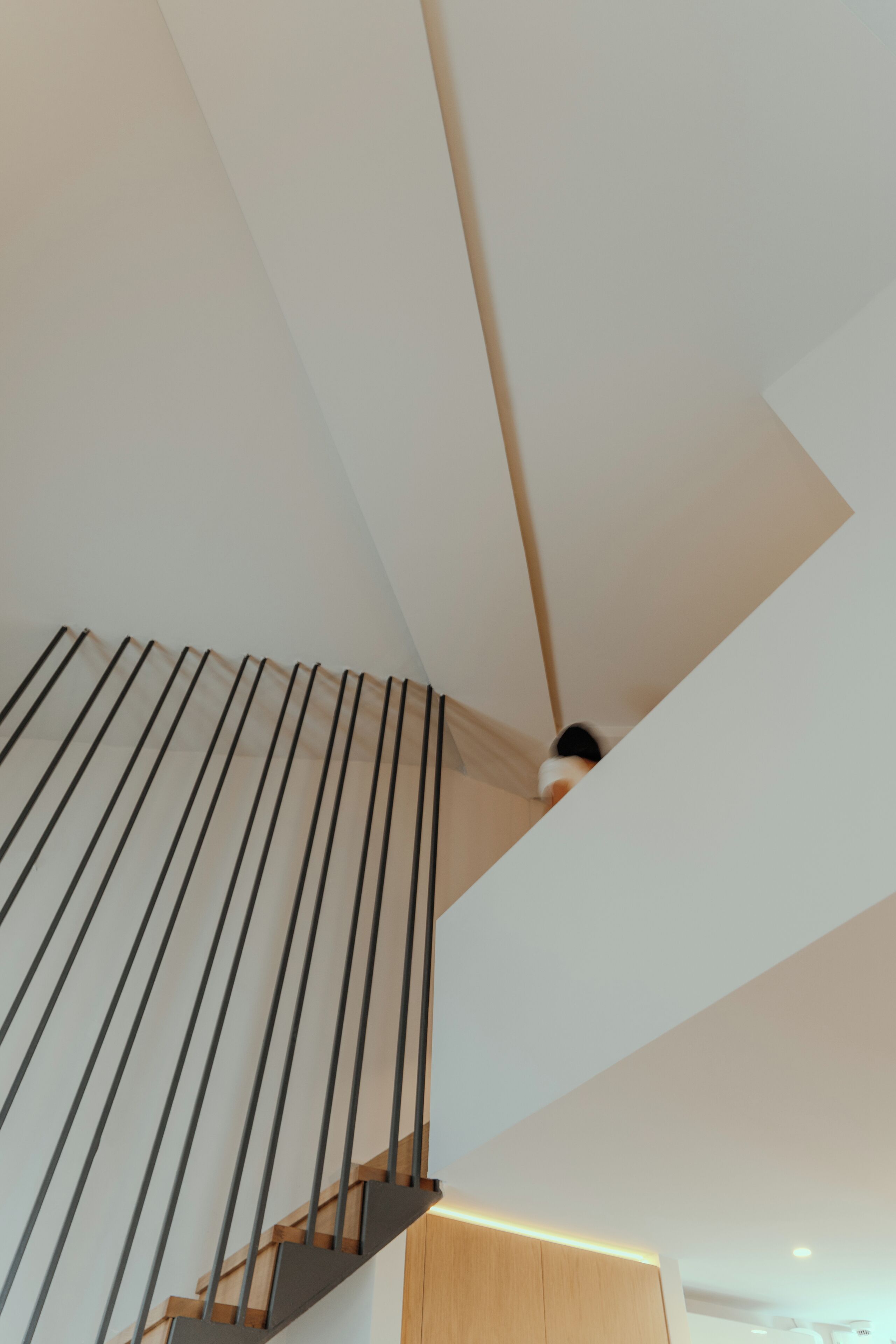 Escadaria moderna com acabamento em madeira e guarda-corpo em metal preto.