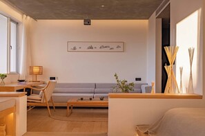 Uma sala de estar moderna com sofá, mesa de centro e escrivaninha com abajur.