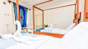Uma cama de dossel com toalha em formato de cisne e colcha azul.