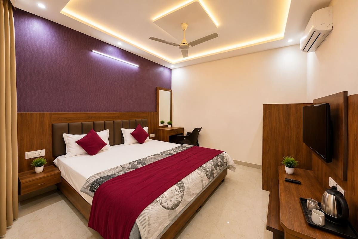 Quarto de hotel moderno com uma cama grande, uma escrivaninha com uma TV, um ventilador de teto e um aparelho de ar condicionado.