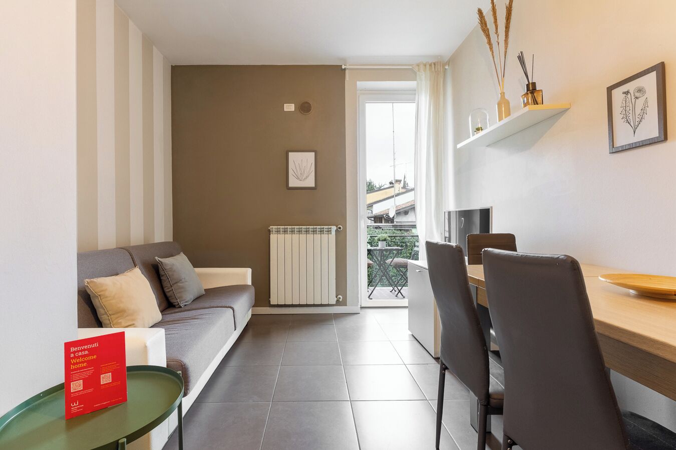 Uma sala de estar moderna com sofá, mesa de jantar com cadeiras, radiador e varanda com vista.