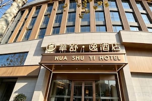 Placa de hotel com o nome 'HUA SHU YI HOTEL' em chinês e inglês.