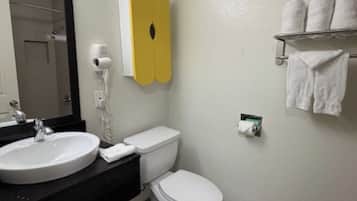 Casa de banho com lavatório, sanita e porta-toalhas.