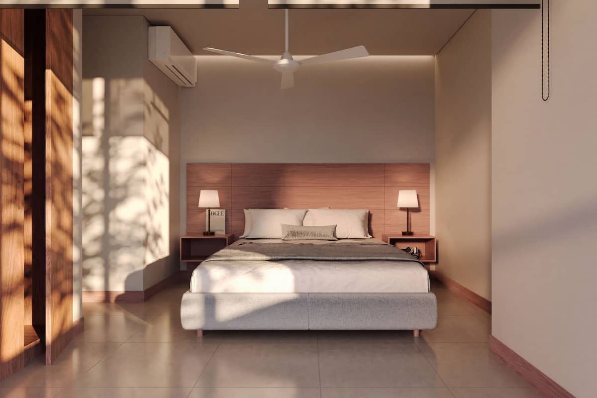 Quarto moderno com uma cama grande, duas mesas de cabeceira, um ventilador de teto e ar-condicionado fixado na parede.