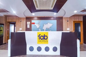 Uma receção com um mapa-múndi, o logótipo 'fab hotels' e um design de teto moderno.
