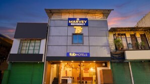 Um edifício com placas indicando 'Marvey Residency' e 'Fab Hotels' na fachada.