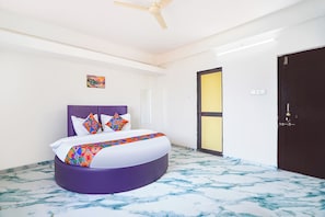 Quarto com cama, ventilador de teto, porta e interruptor de luz na parede.